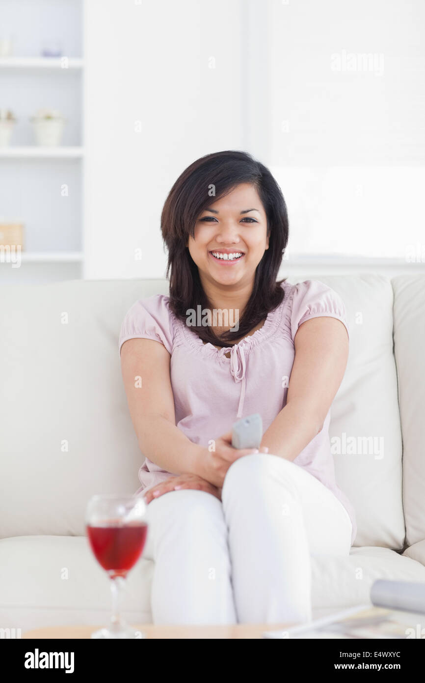 Smiling woman sitting on a couch Stock Photo - Alamy