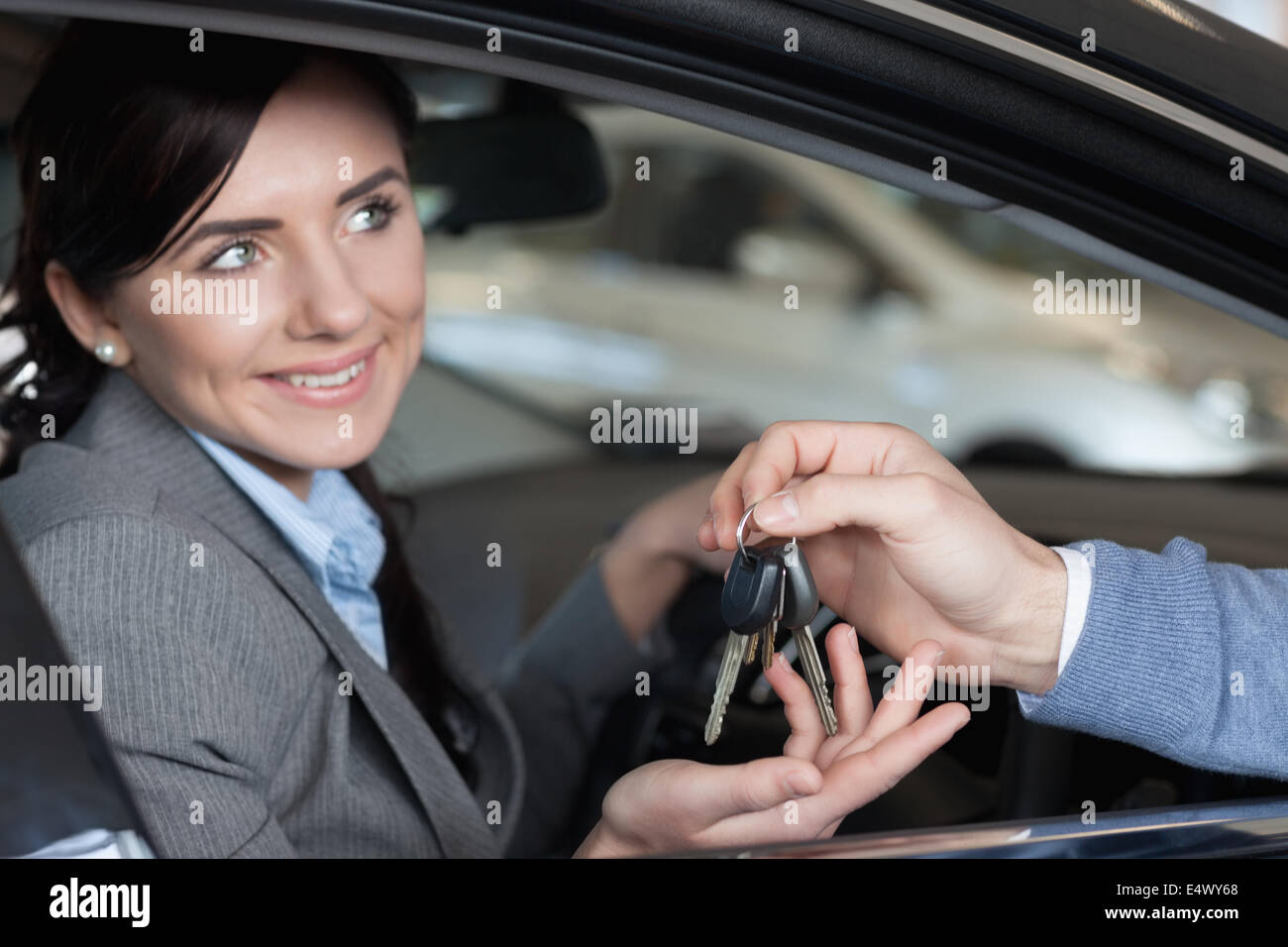 Smiling woman receiving keys from a man Stock Photo - Alamy