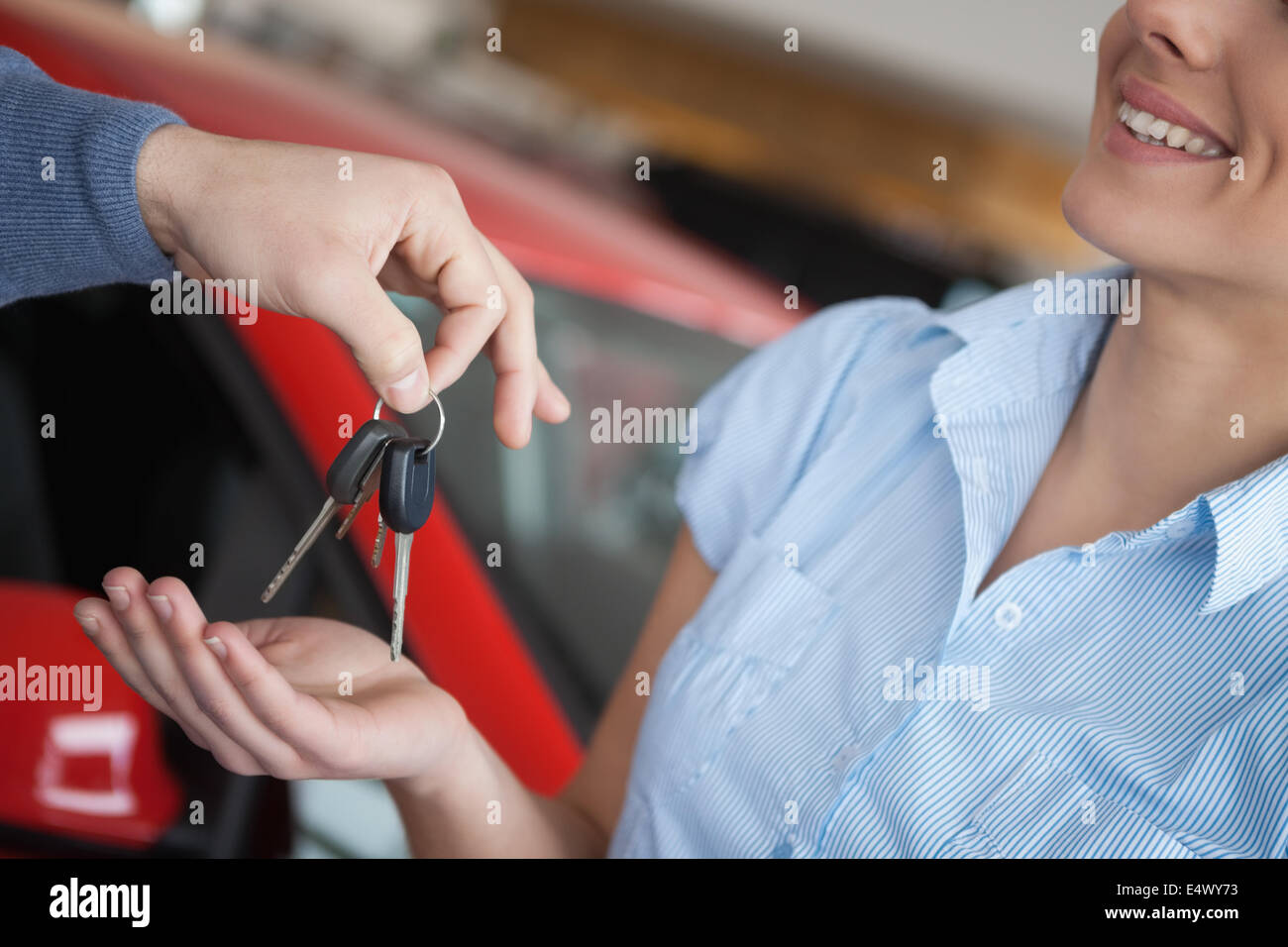 Smiling woman receiving keys from somebody Stock Photo - Alamy