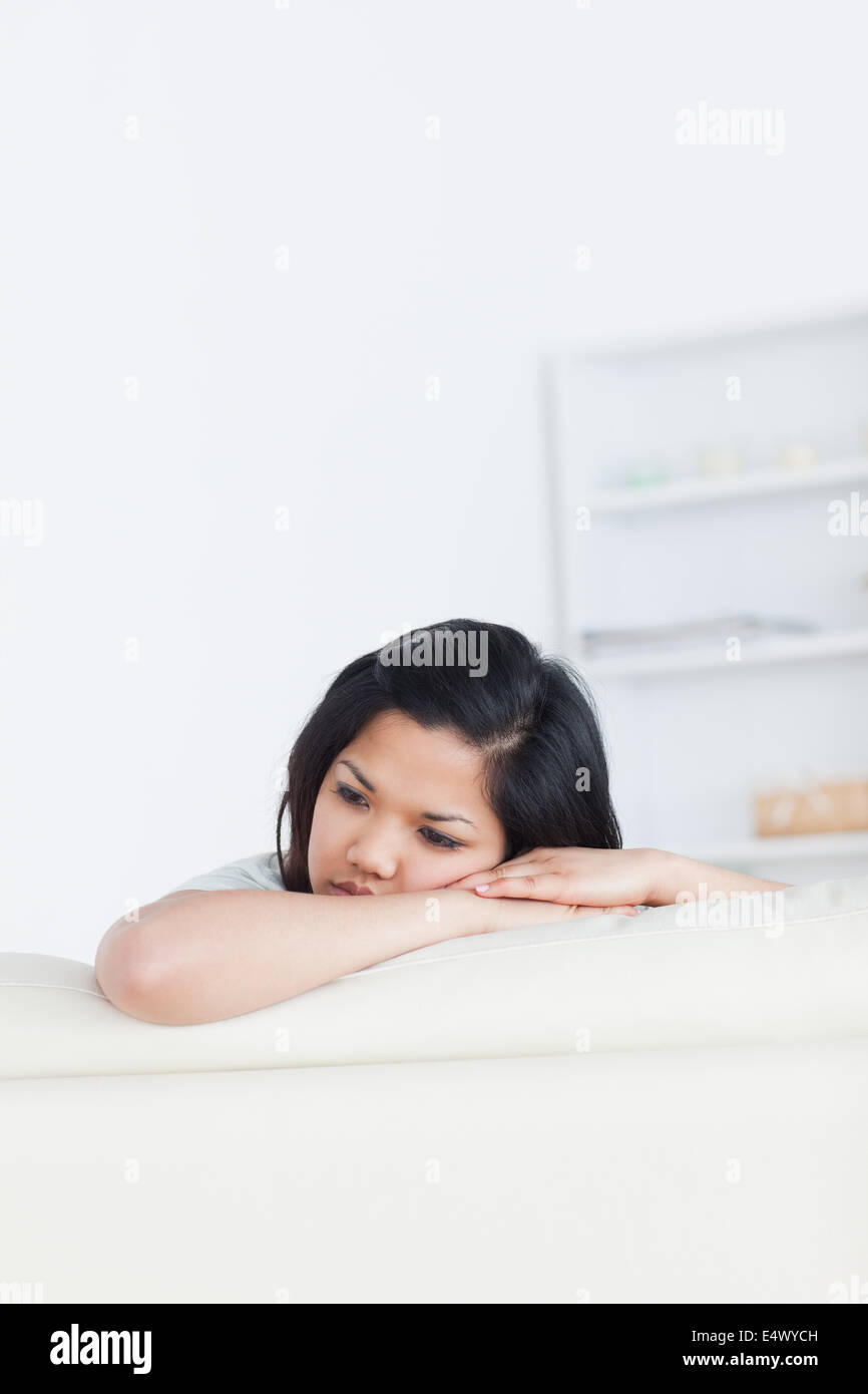 Sad woman resting her face on a sofa Stock Photo - Alamy