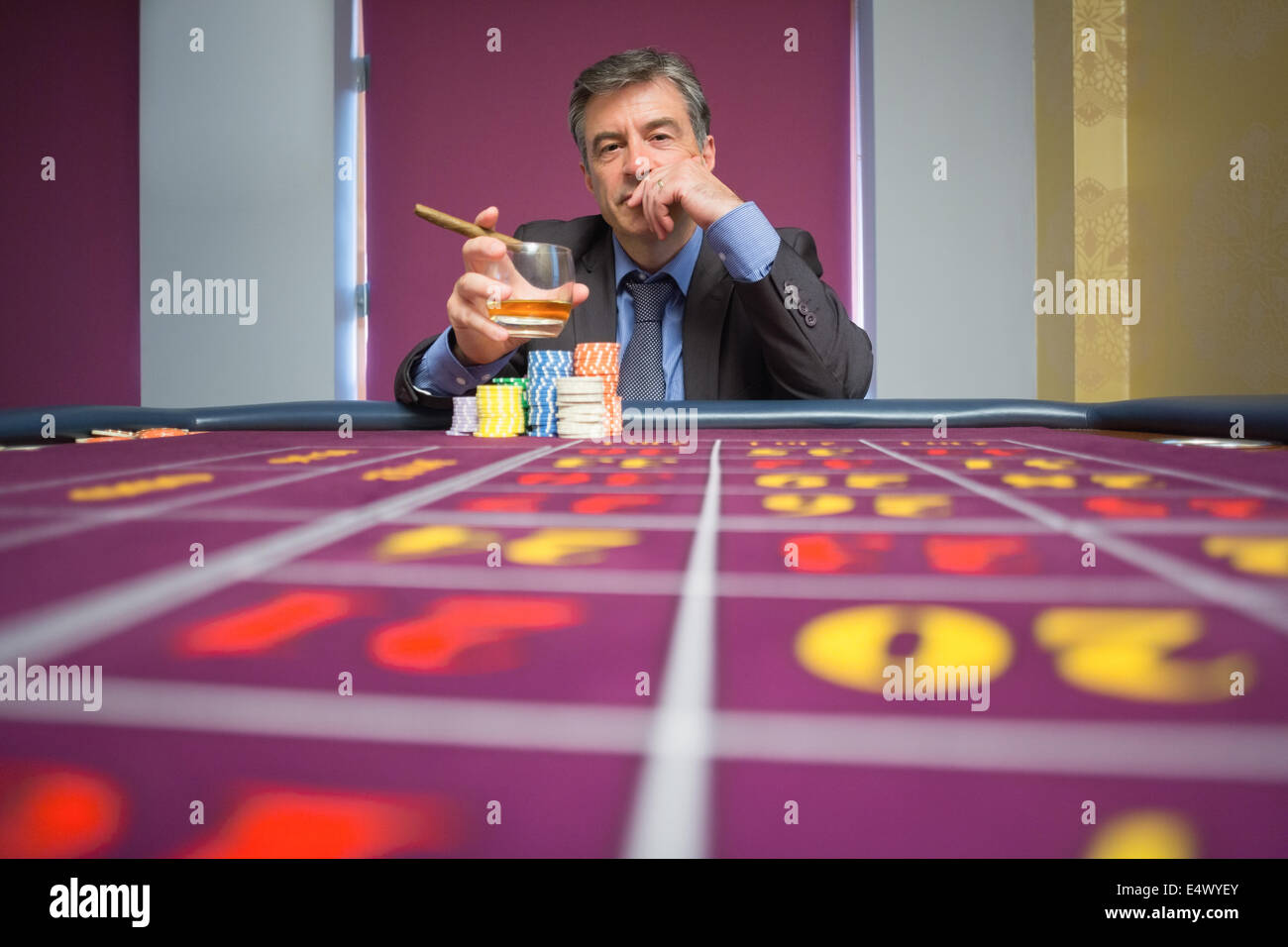 Man sitting at roulette table Stock Photo - Alamy