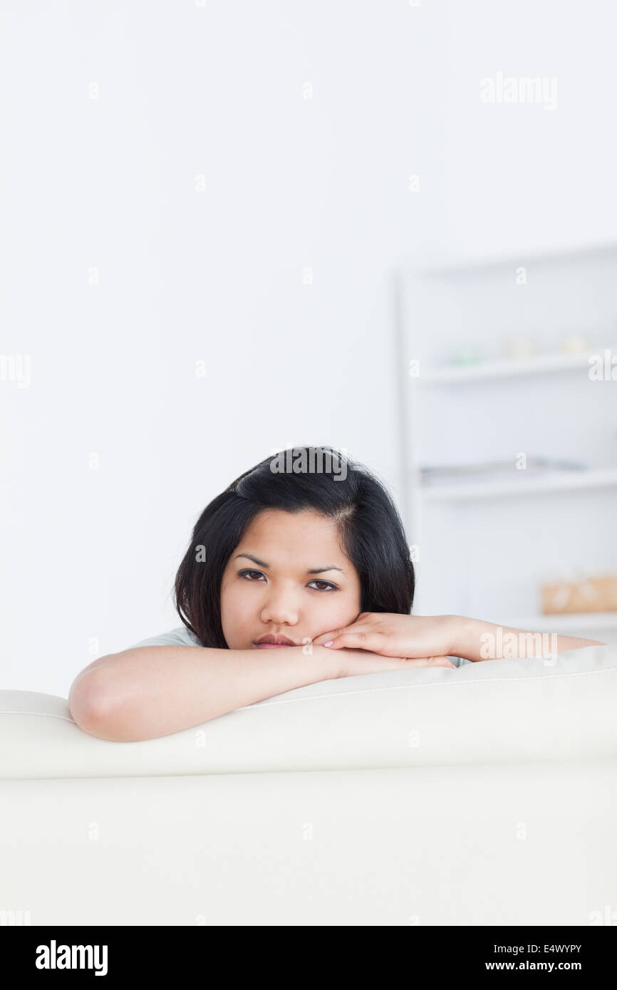 Woman resting her face on a sofa Stock Photo - Alamy