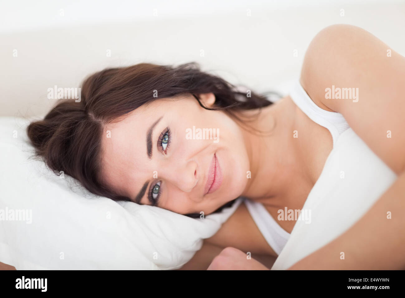 Smiling brunette woman waking up Stock Photo - Alamy