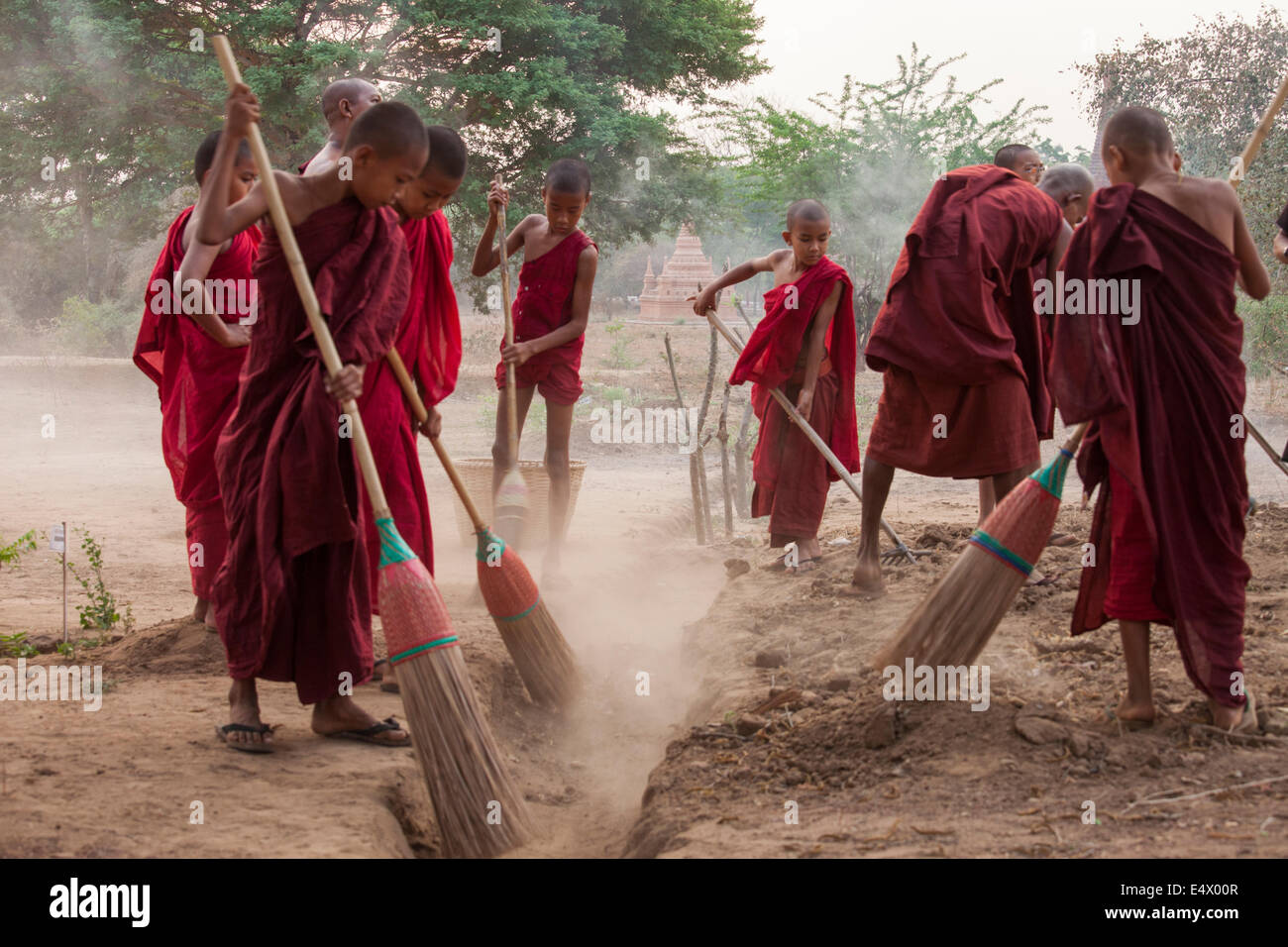 Monks at monastery in Bagan, Myanmar, use brooms to sweep trash and ...