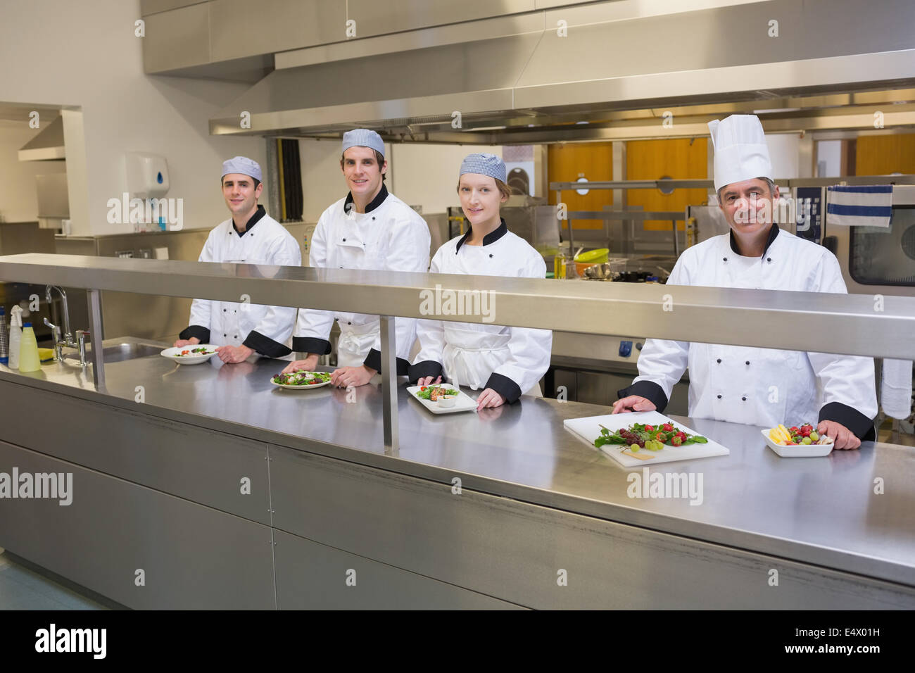 Four happy Chef's in the kitchen Stock Photo - Alamy