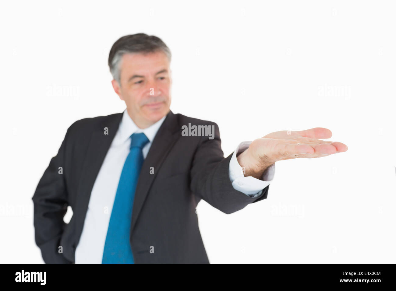 Serious businessman holding out hand Stock Photo - Alamy