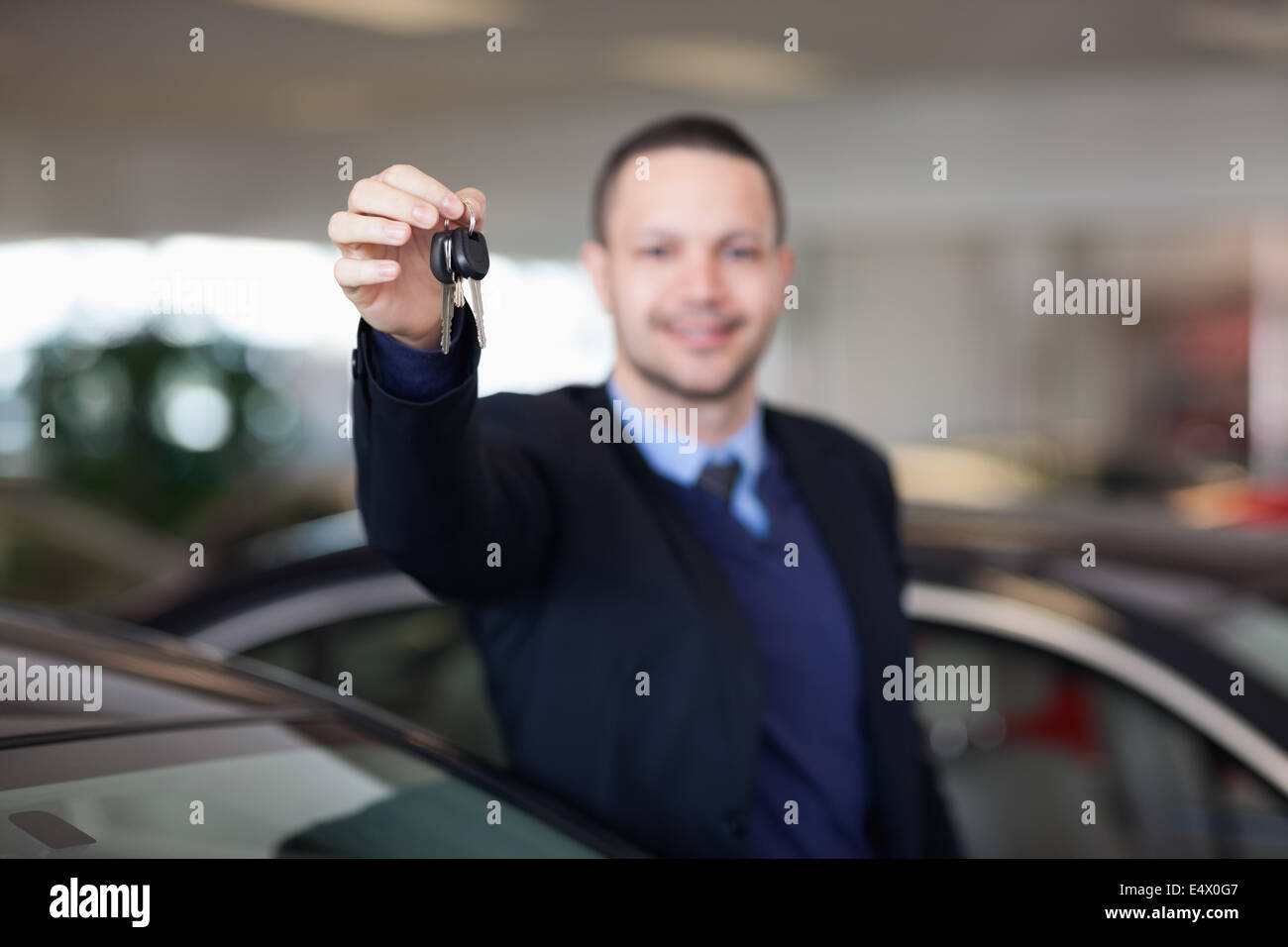 Dealer standing while holding car keys Stock Photo - Alamy