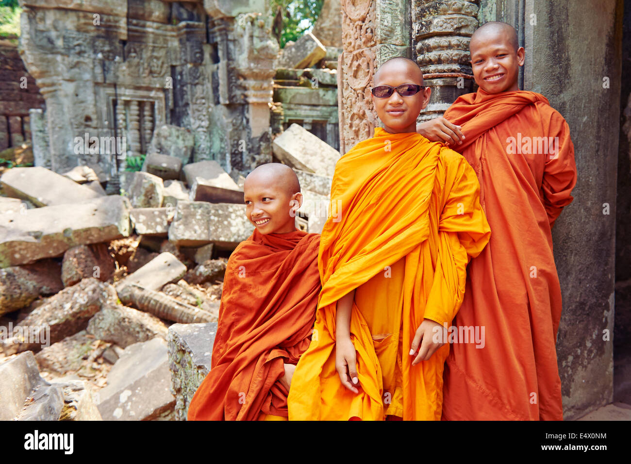 3 monks playing with sunglasses at the Ta Prohm temple in Cambodia ...