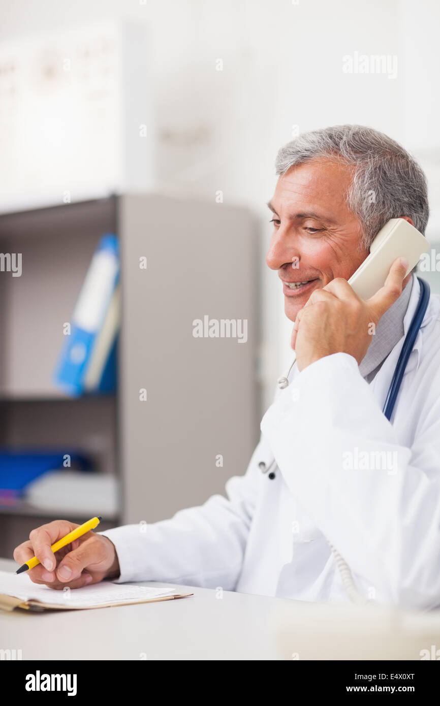 Doctor calling while holding a pen Stock Photo - Alamy