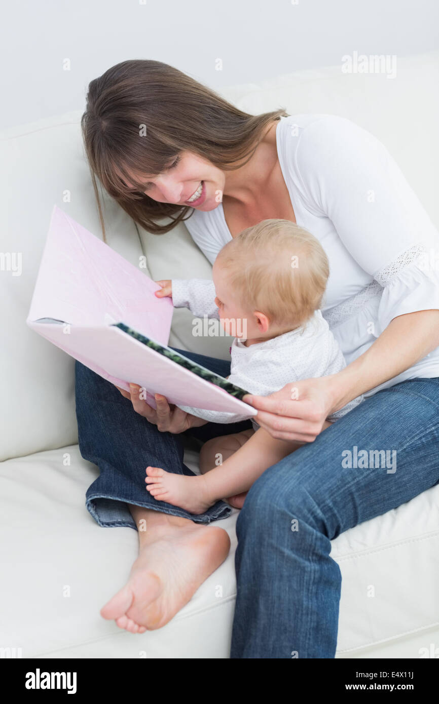Baby holding a book with a mother Stock Photo - Alamy