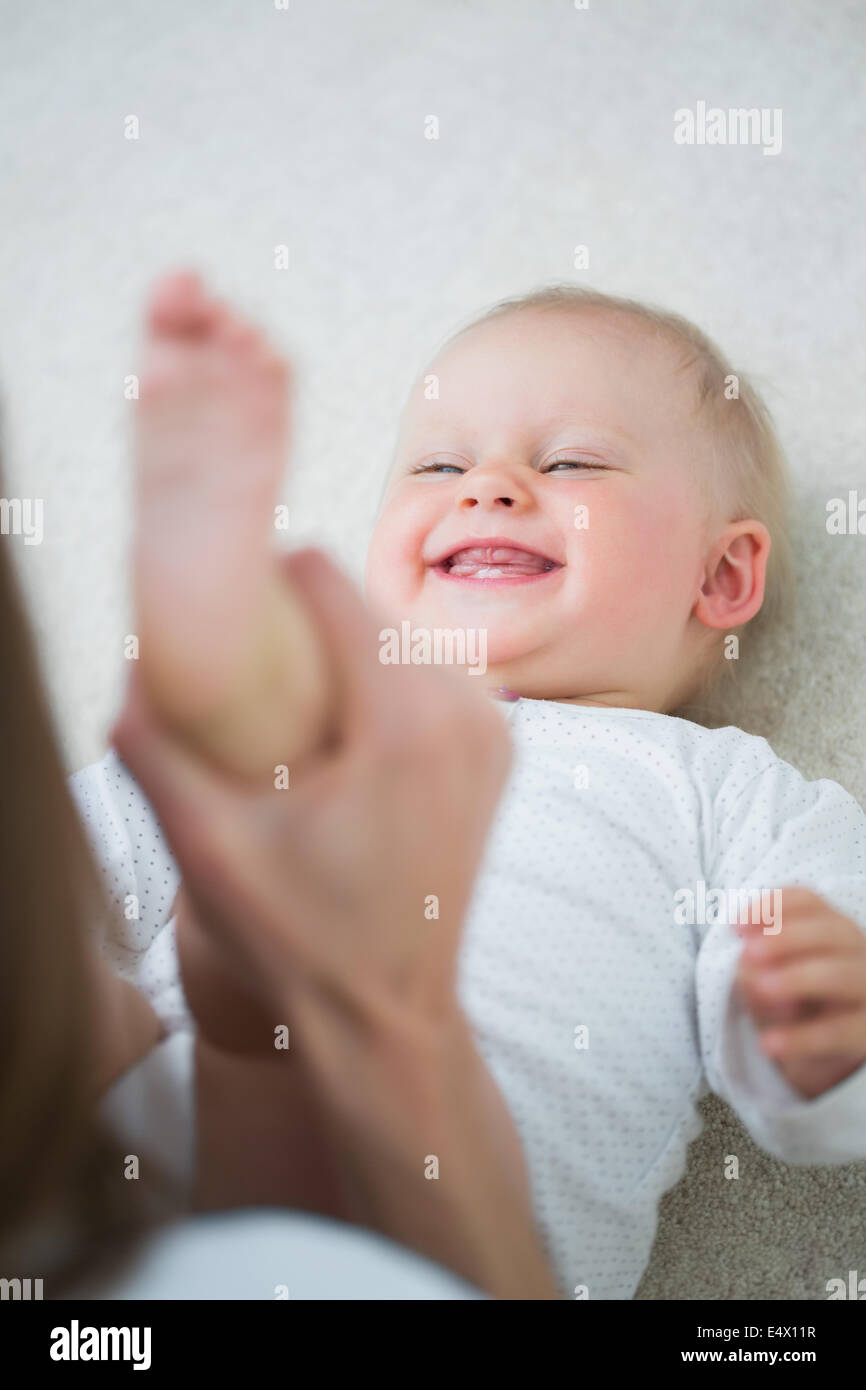 Mother raising the leg of a baby Stock Photo - Alamy