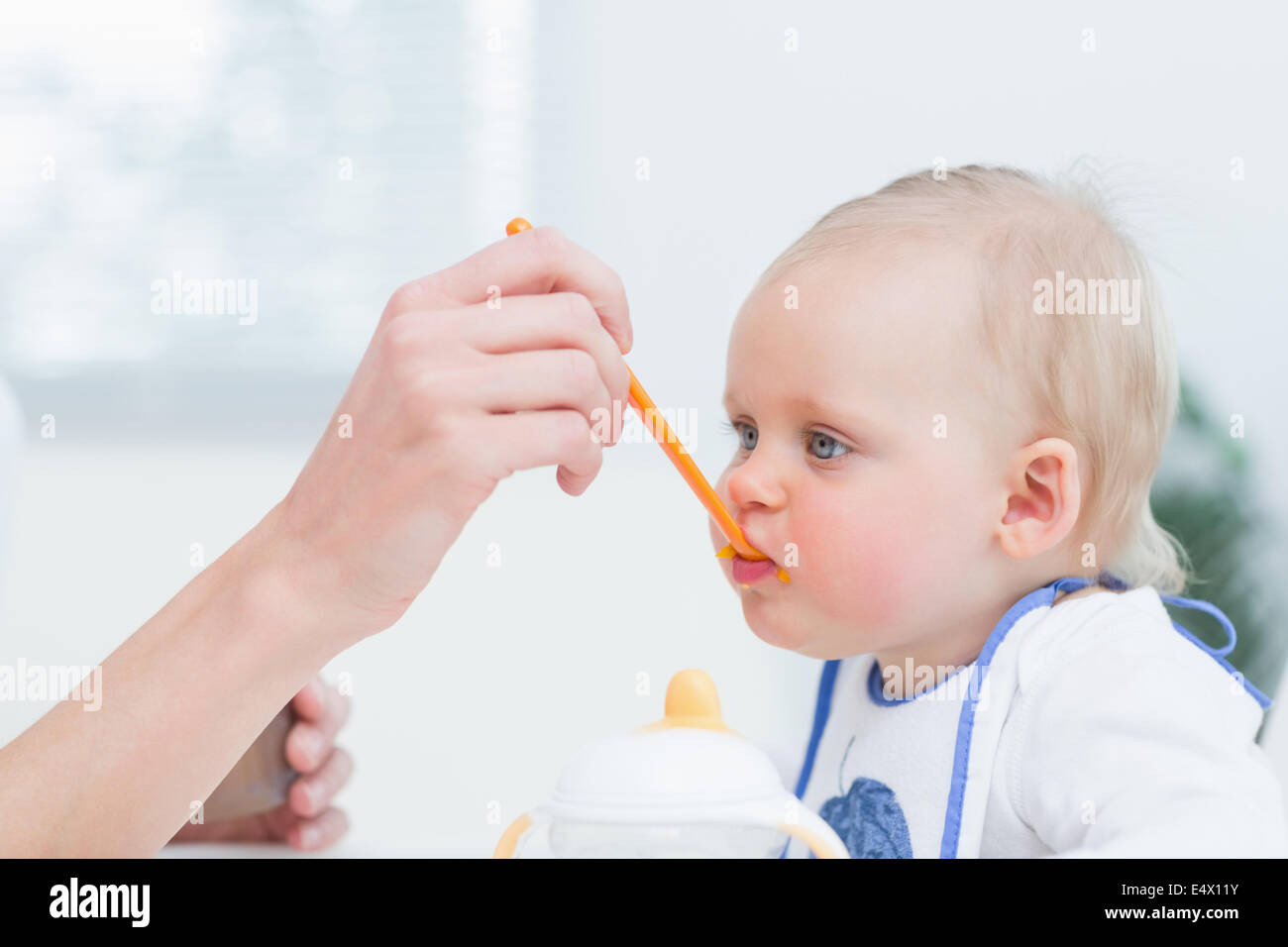 Baby with a plastic spoon on his mouth Stock Photo - Alamy