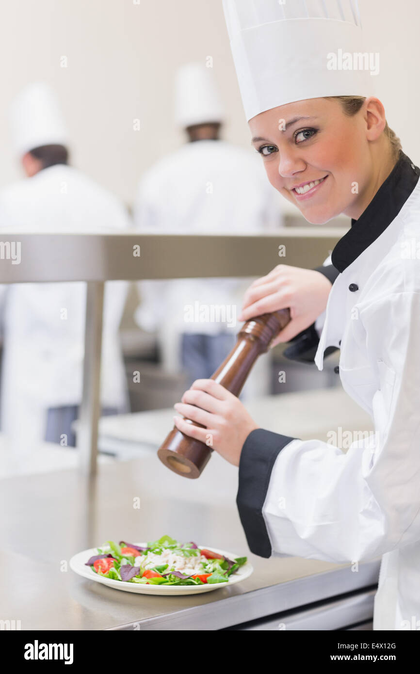 Chef adding pepper to salad Stock Photo - Alamy