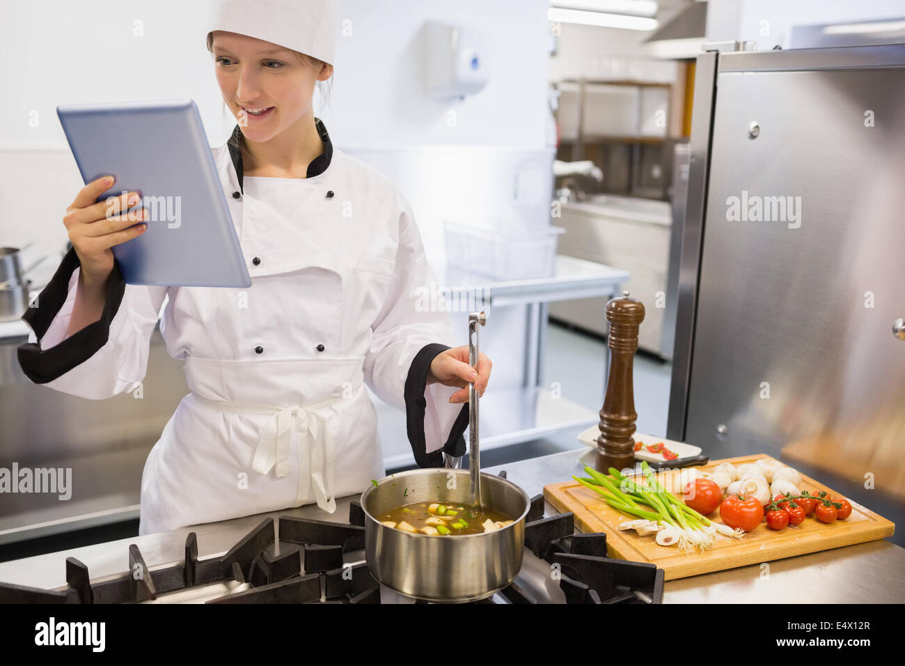 Female chef using tablet pc while cooking Stock Photo - Alamy