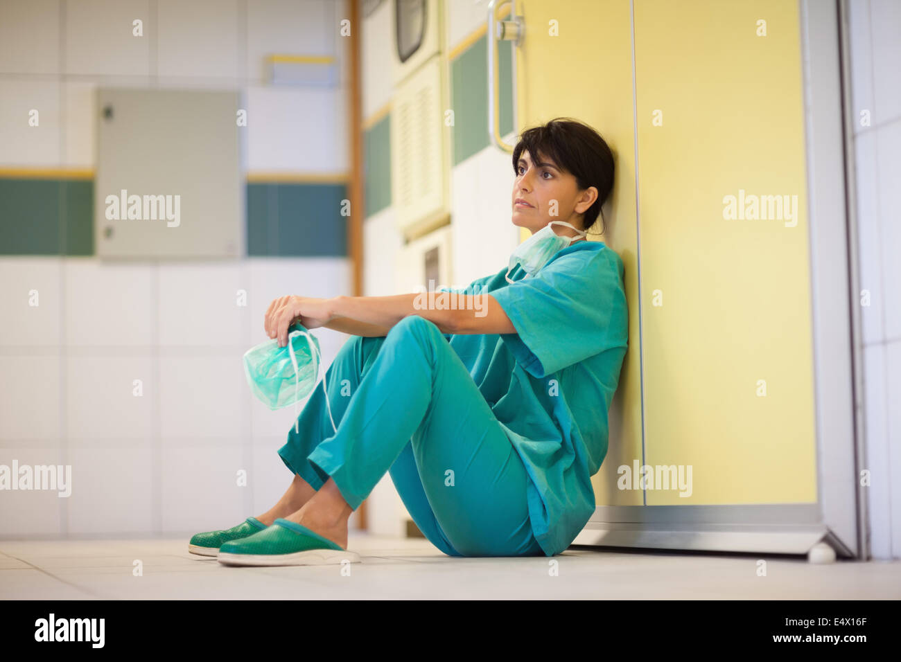 Thinking surgeon sitting on the floor Stock Photo - Alamy