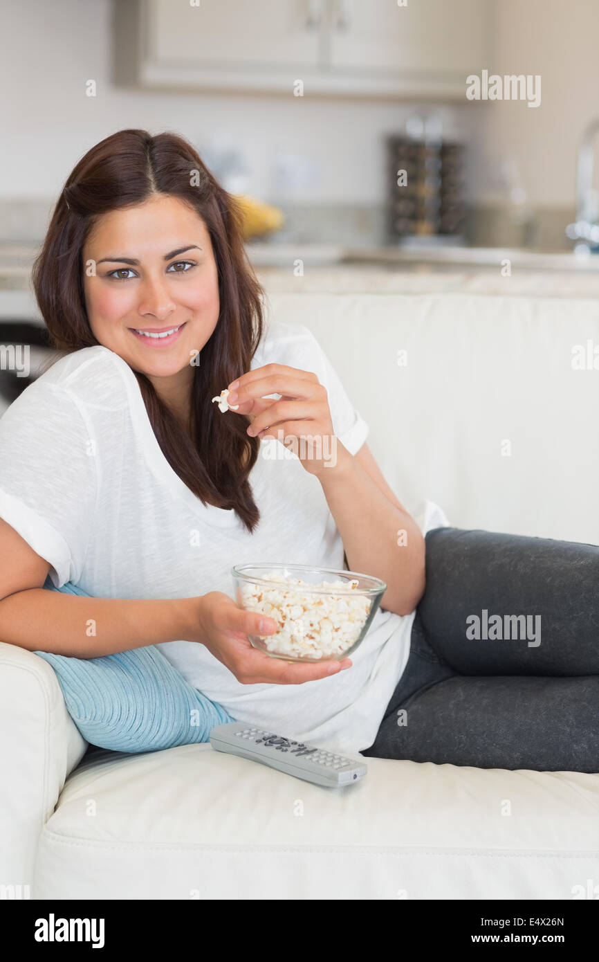 Brunette eating popcorn and relaxing Stock Photo - Alamy