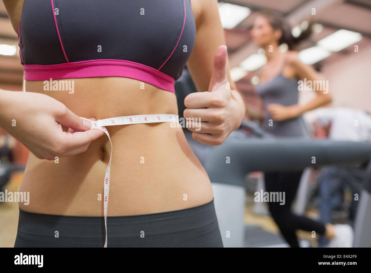 Muscular female measuring her waist hi-res stock photography and images ...