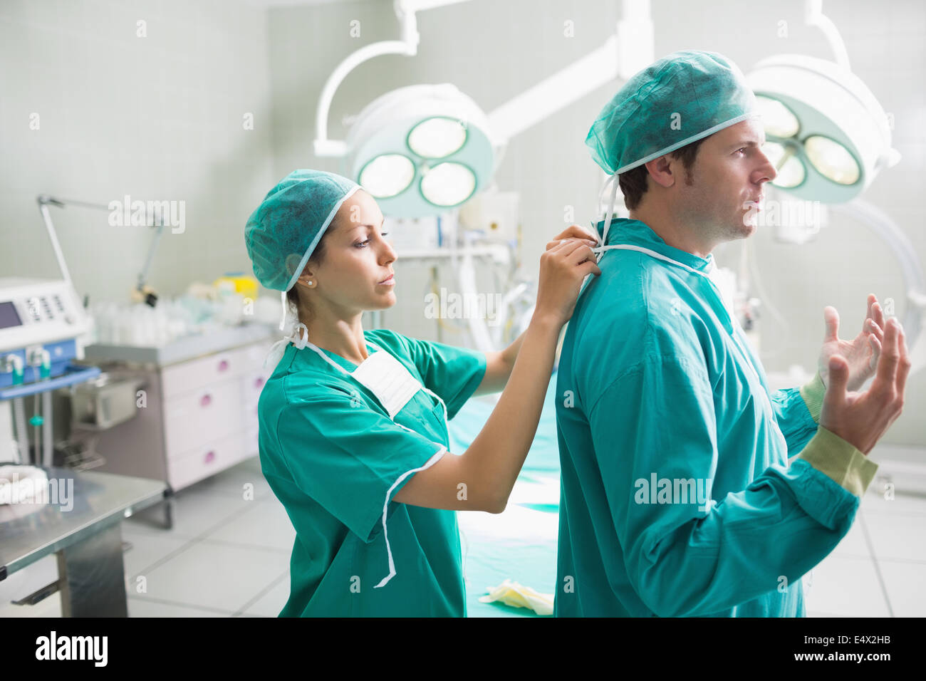 Side view of a nurse helping a surgeon Stock Photo - Alamy