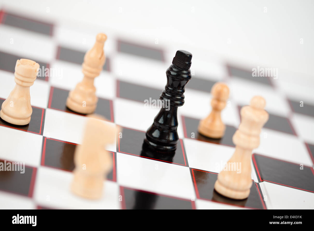 Black queen surrounded by white chess pieces Stock Photo - Alamy