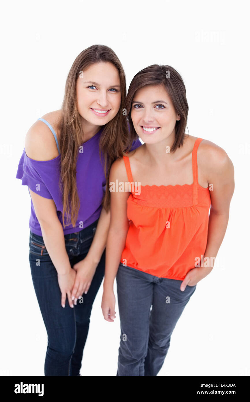 Two teenage girls leaning forward Stock Photo - Alamy