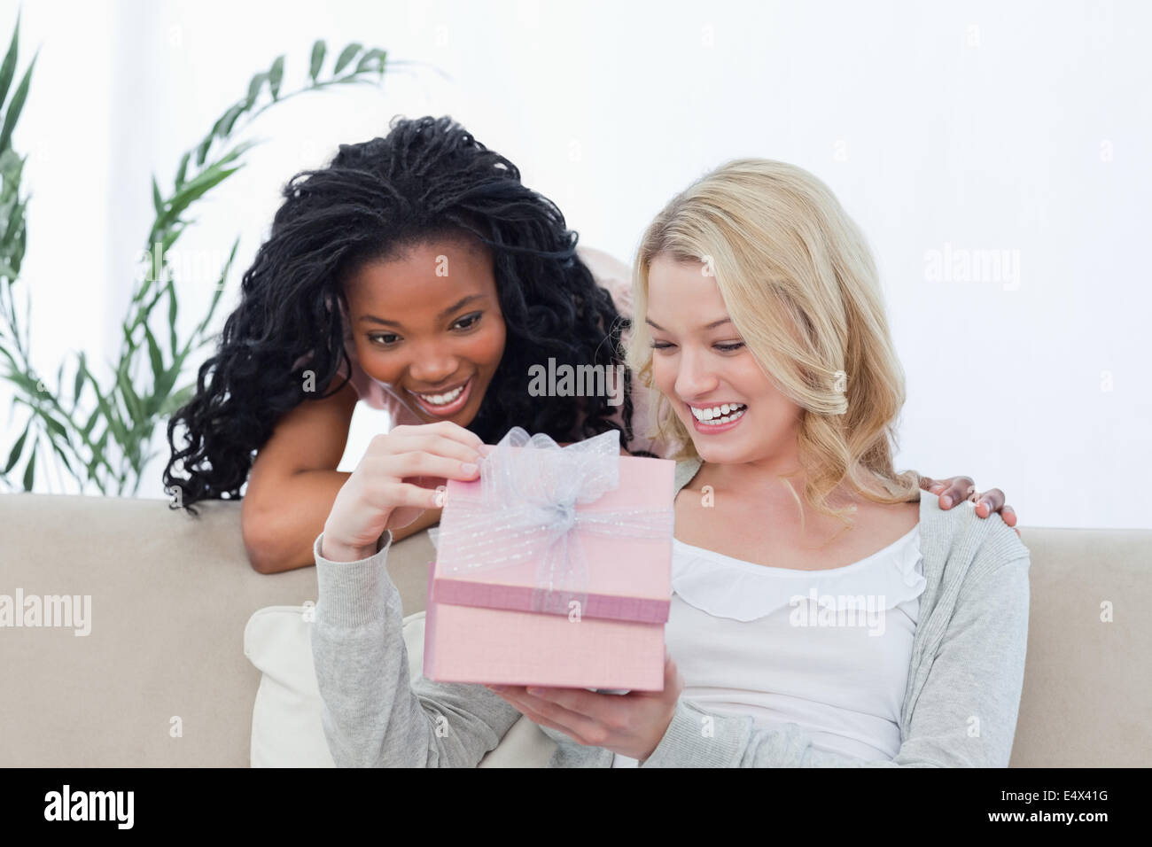 Two women look inside a pink box Stock Photo - Alamy