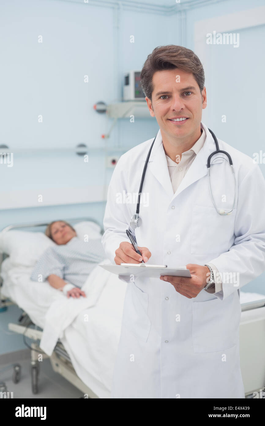 Doctor holding a chart while smiling Stock Photo - Alamy