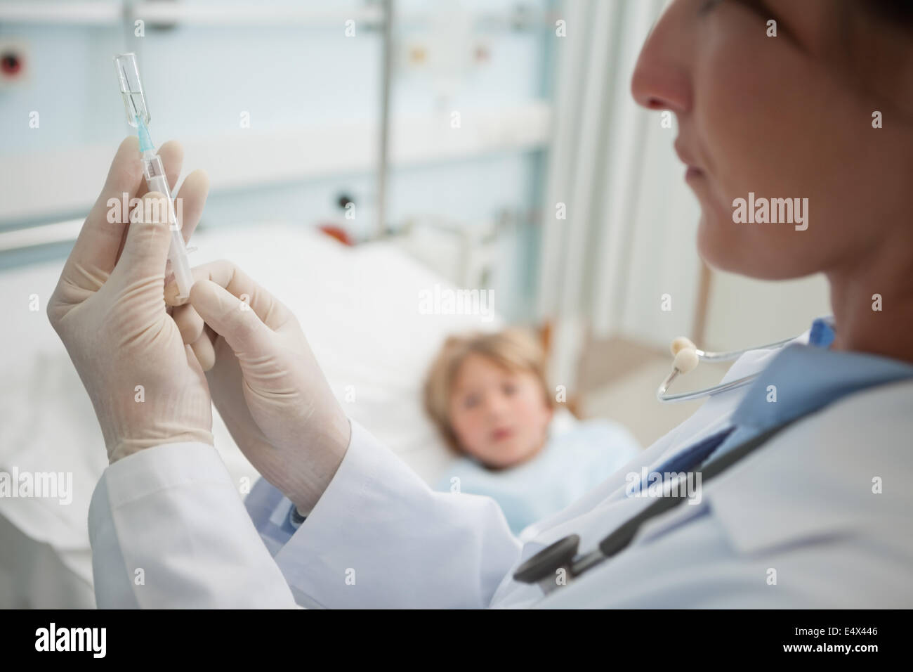 Doctor preparing a syringe next to a child Stock Photo - Alamy