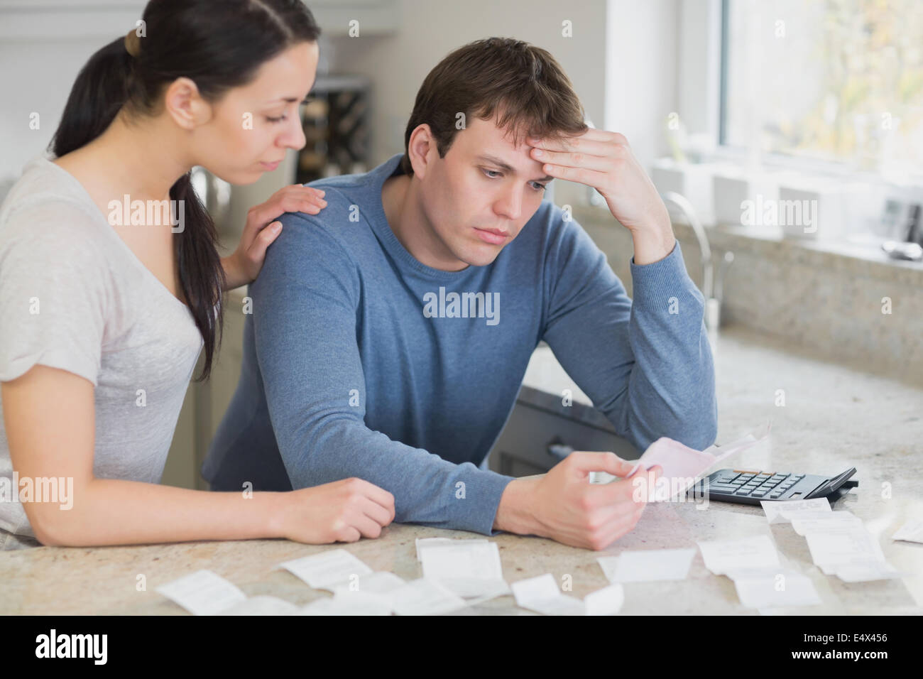 Worried couple looking over bills Stock Photo - Alamy