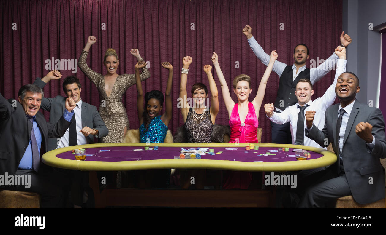 Cheering group at poker table Stock Photo - Alamy