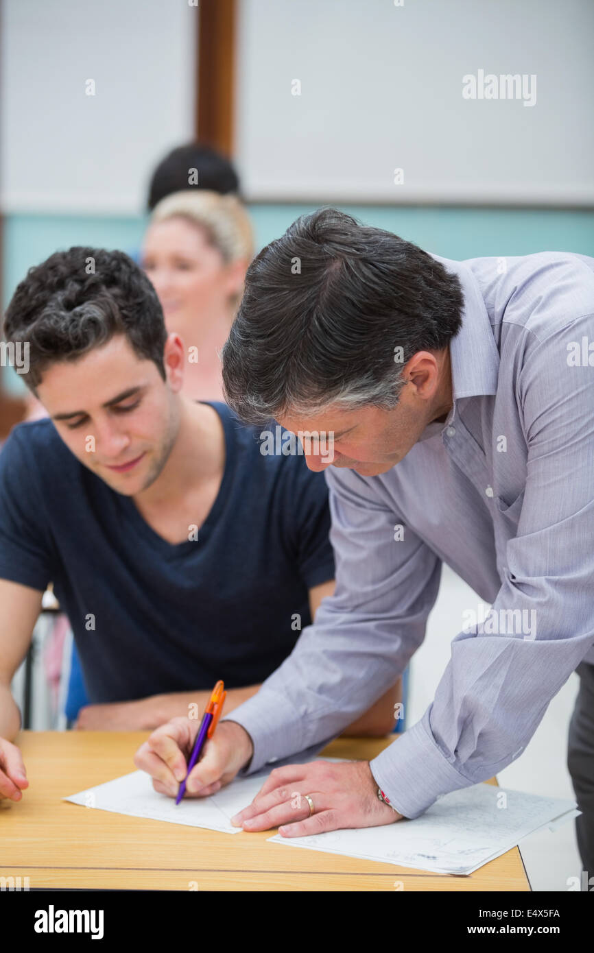 Teacher making note on students work Stock Photo - Alamy