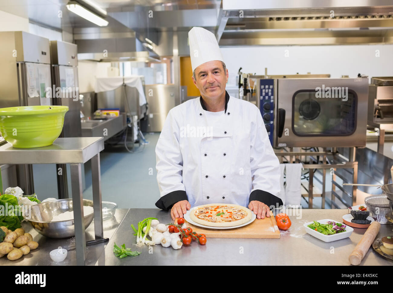 Chef standing in the kitchen with pizza Stock Photo - Alamy
