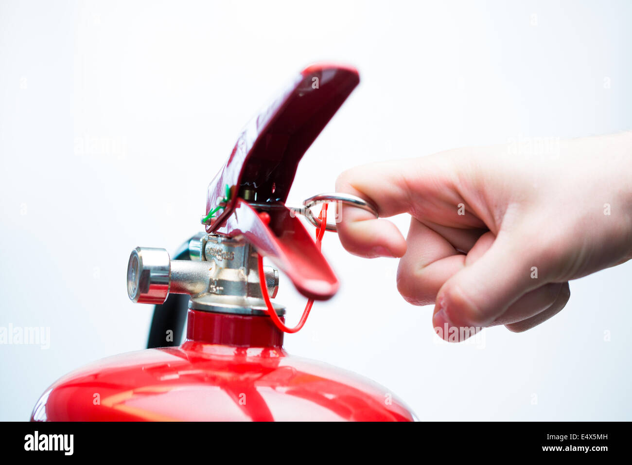 Pulling pin of fire extinguisher Stock Photo - Alamy