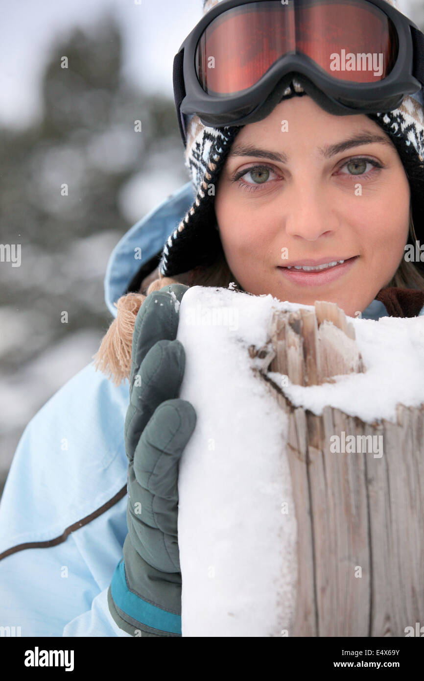 Woman standing behind a wooden post Stock Photo - Alamy