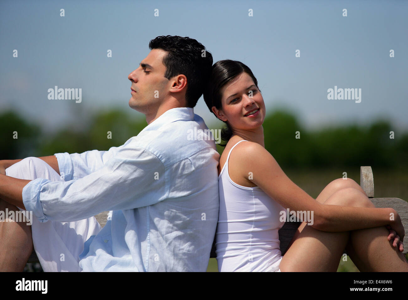 Young couple sitting in the sunshine Stock Photo - Alamy