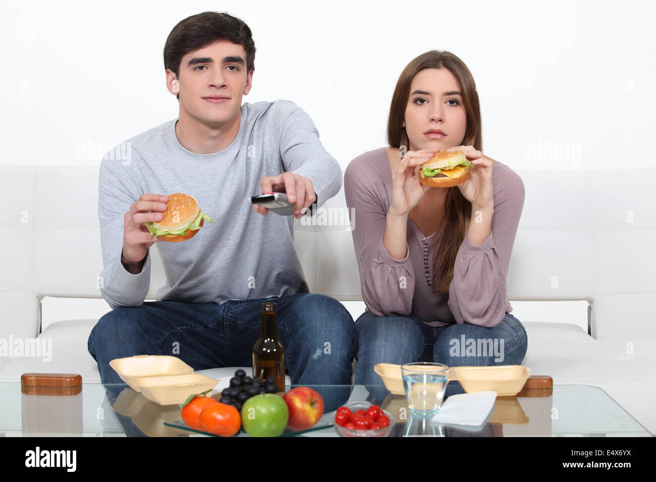 Young couple eating burgers Stock Photo - Alamy