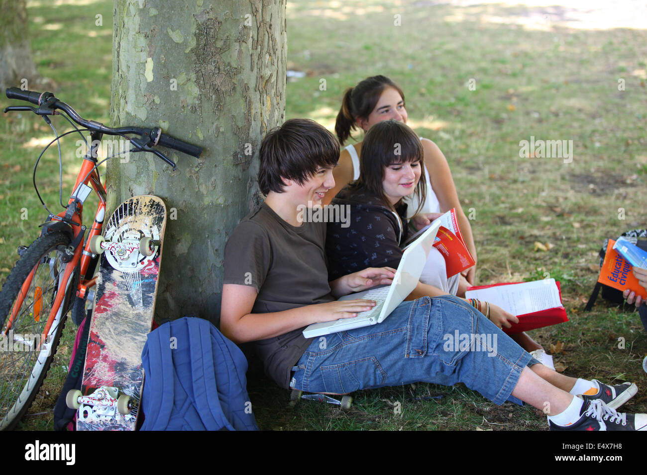 Teenagers sitting at the foot of a tree Stock Photo - Alamy
