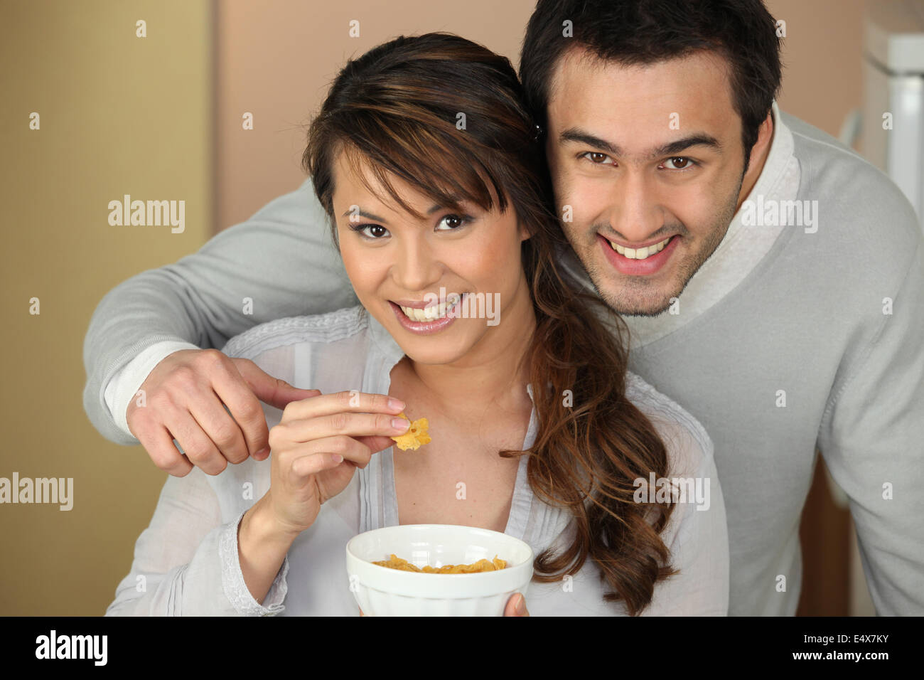 Couple eating from bowl Stock Photo - Alamy