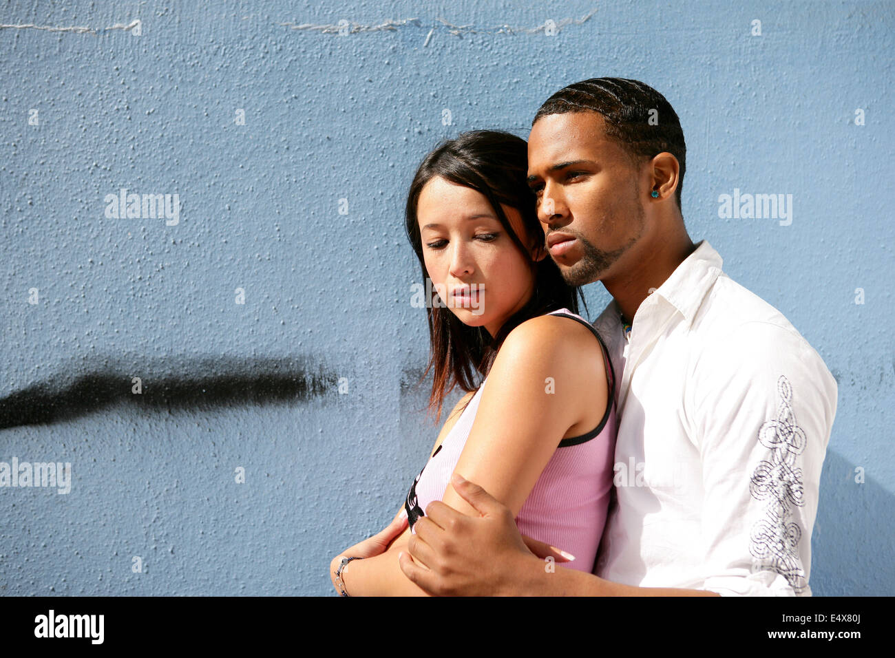 Teens embracing in front of a wall Stock Photo - Alamy