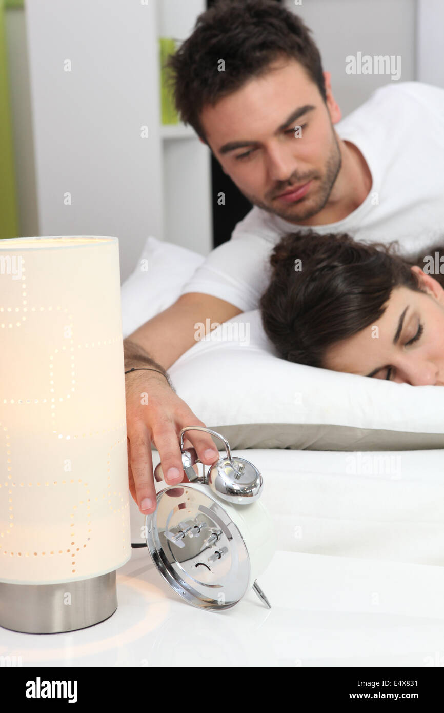 Couple in bed waking up Stock Photo - Alamy