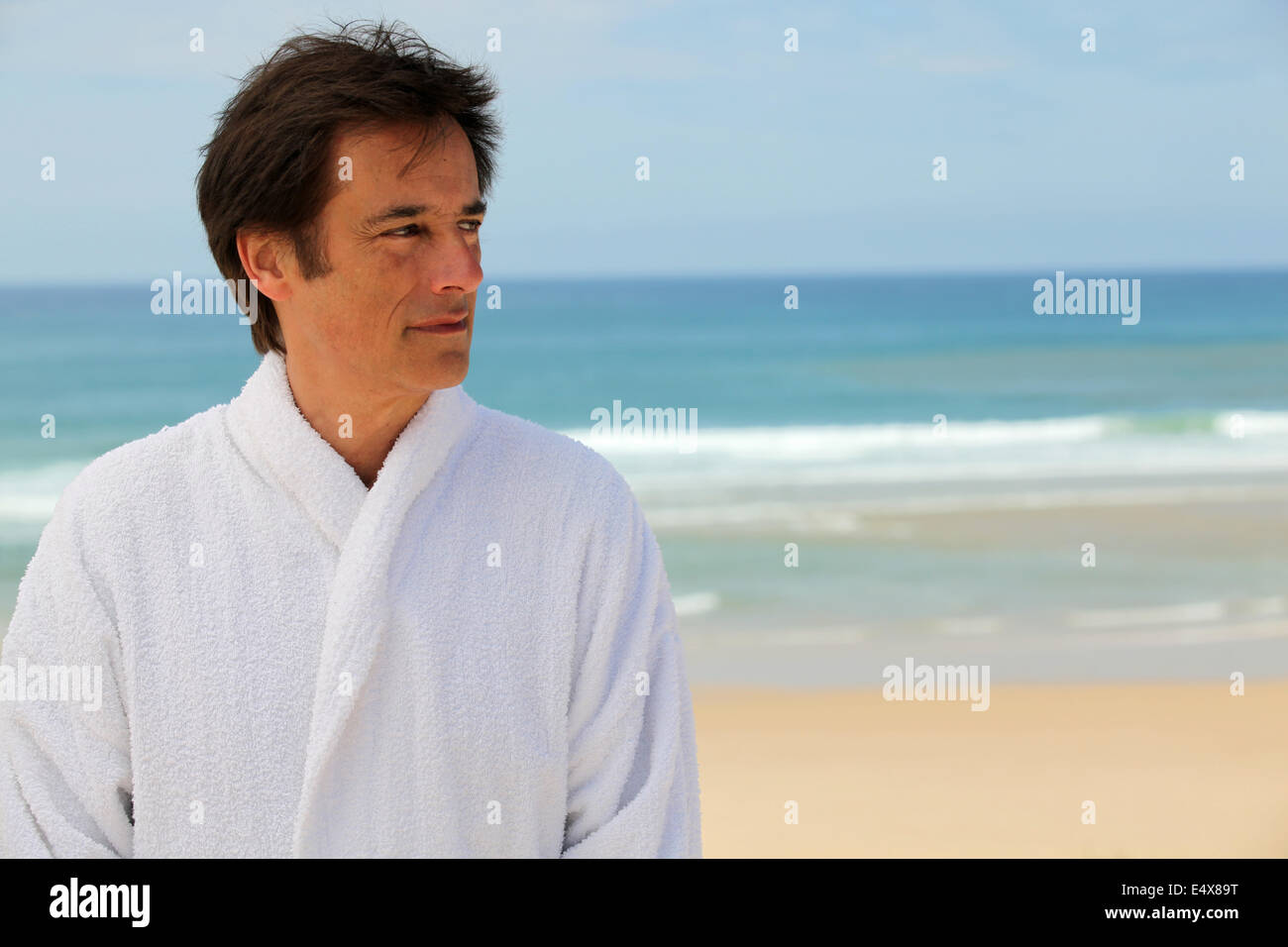 Man in bathrobe on the beach Stock Photo - Alamy