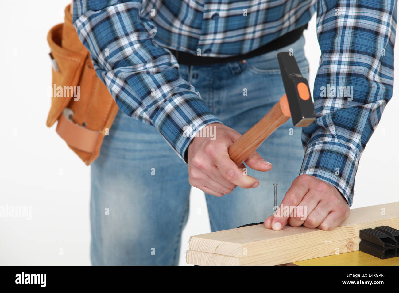Man hammering nail into wood Stock Photo - Alamy