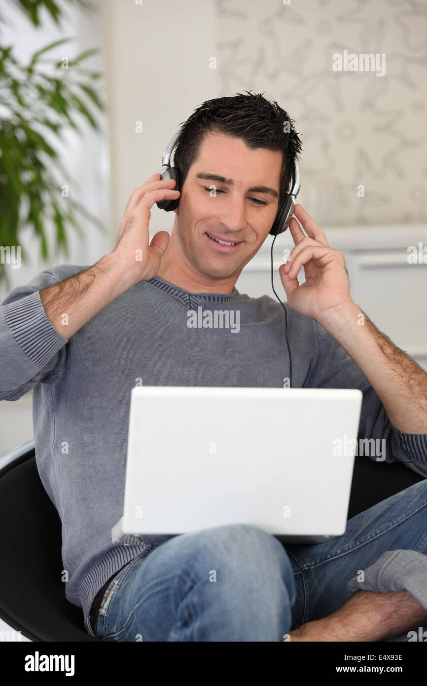 Young man headphones looking laptop hi-res stock photography and images ...