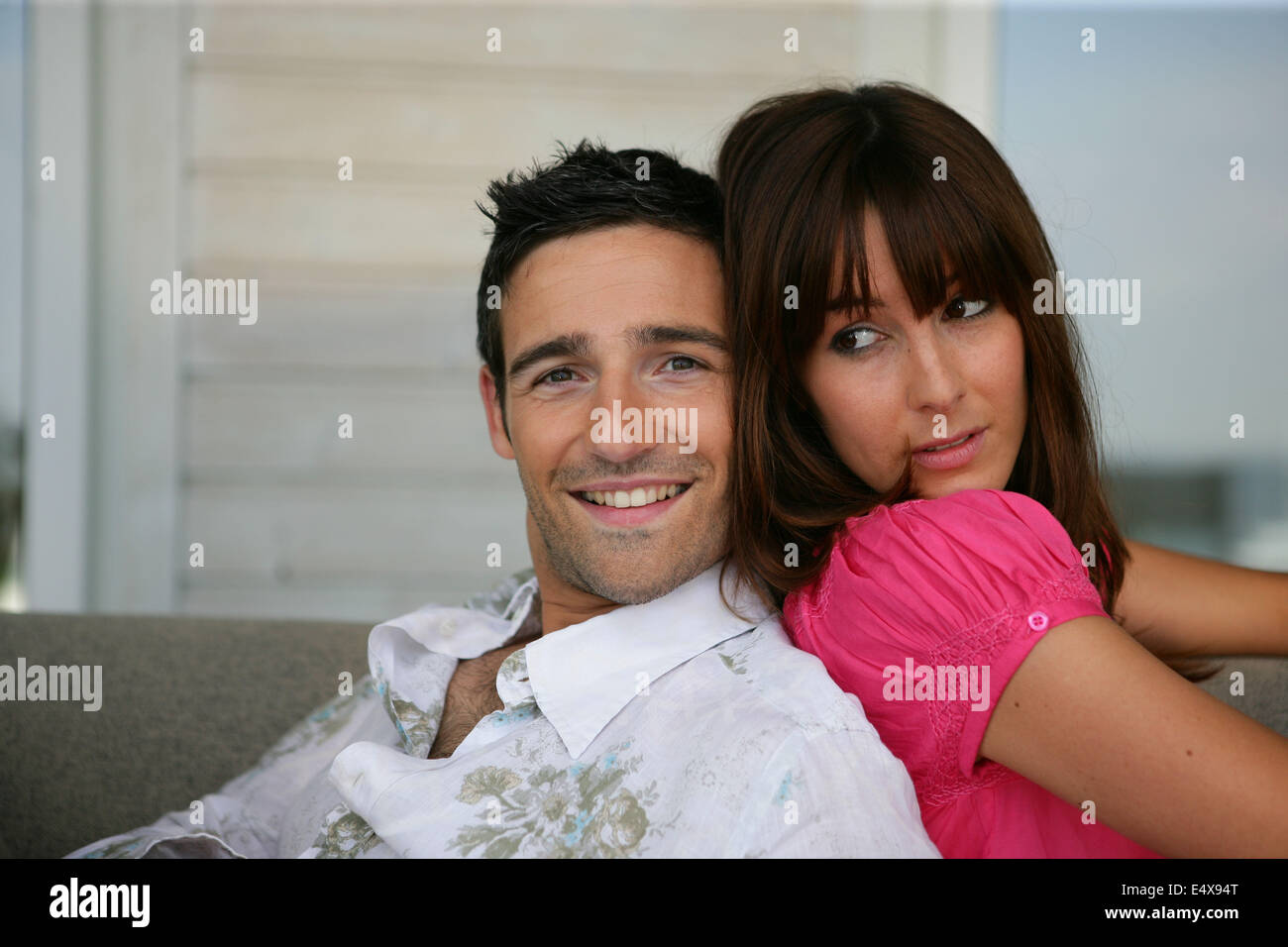 Couple sitting back to back Stock Photo - Alamy