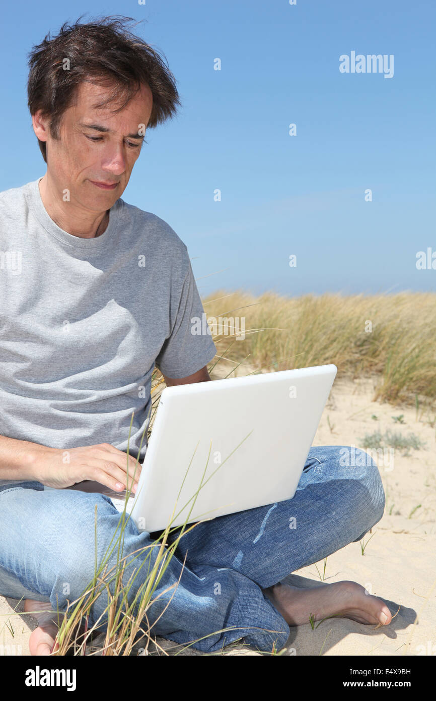 Man on laptop at the seaside Stock Photo - Alamy