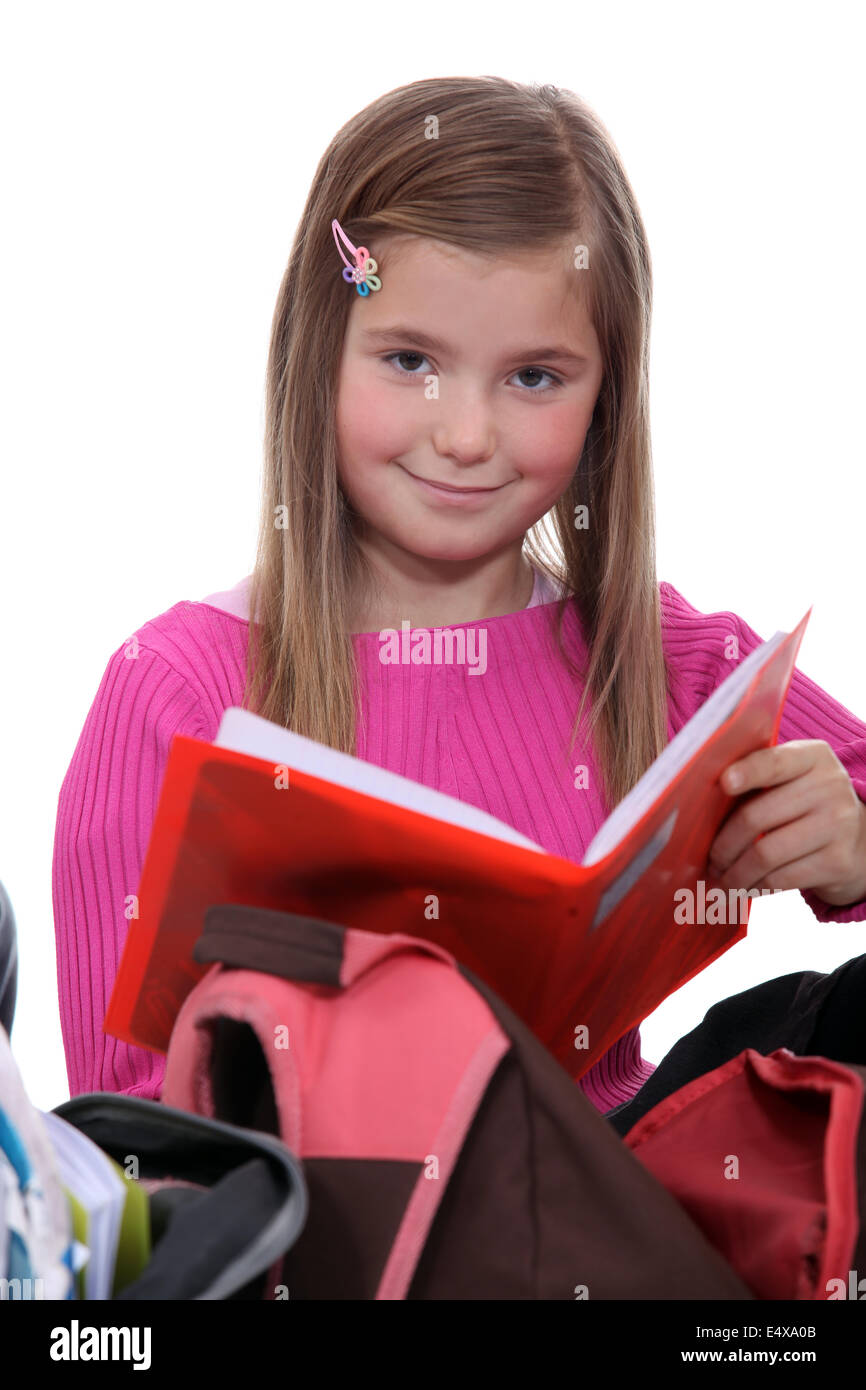 Schoolgirl removing book from backpack Stock Photo - Alamy