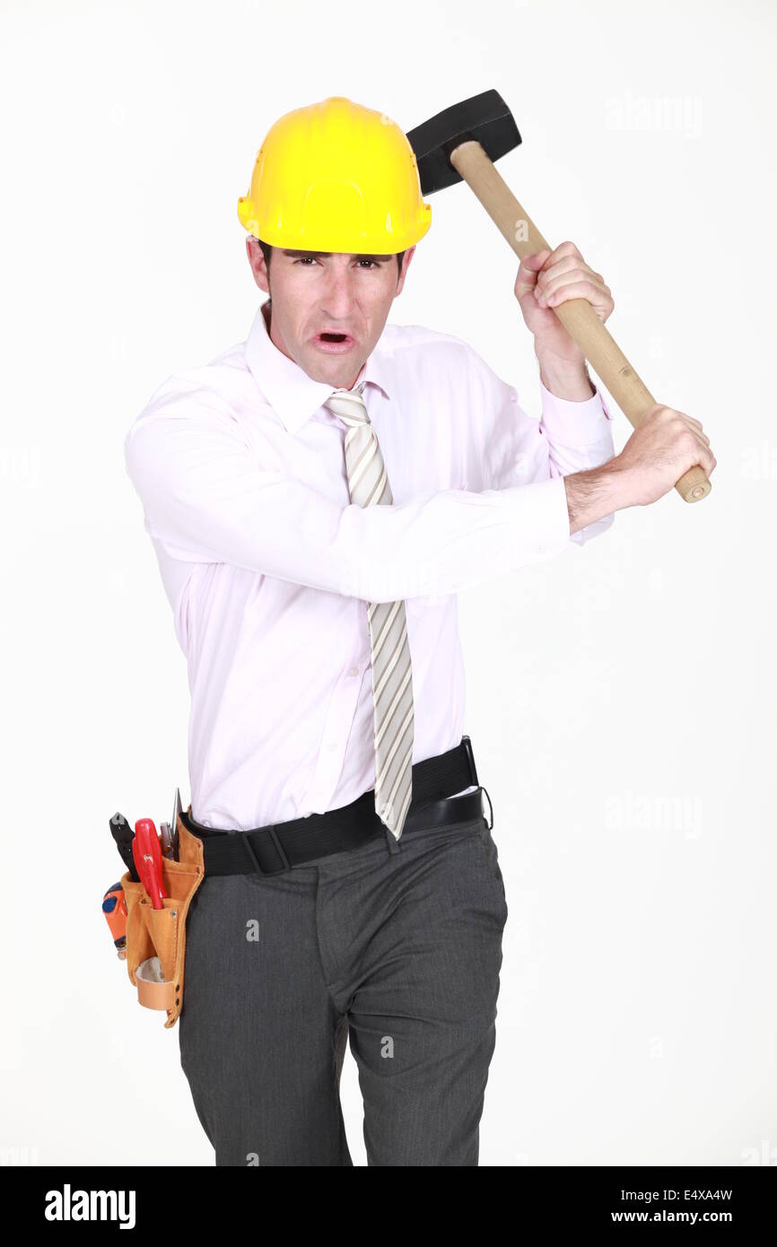 Angry engineer waving a mallet around Stock Photo - Alamy