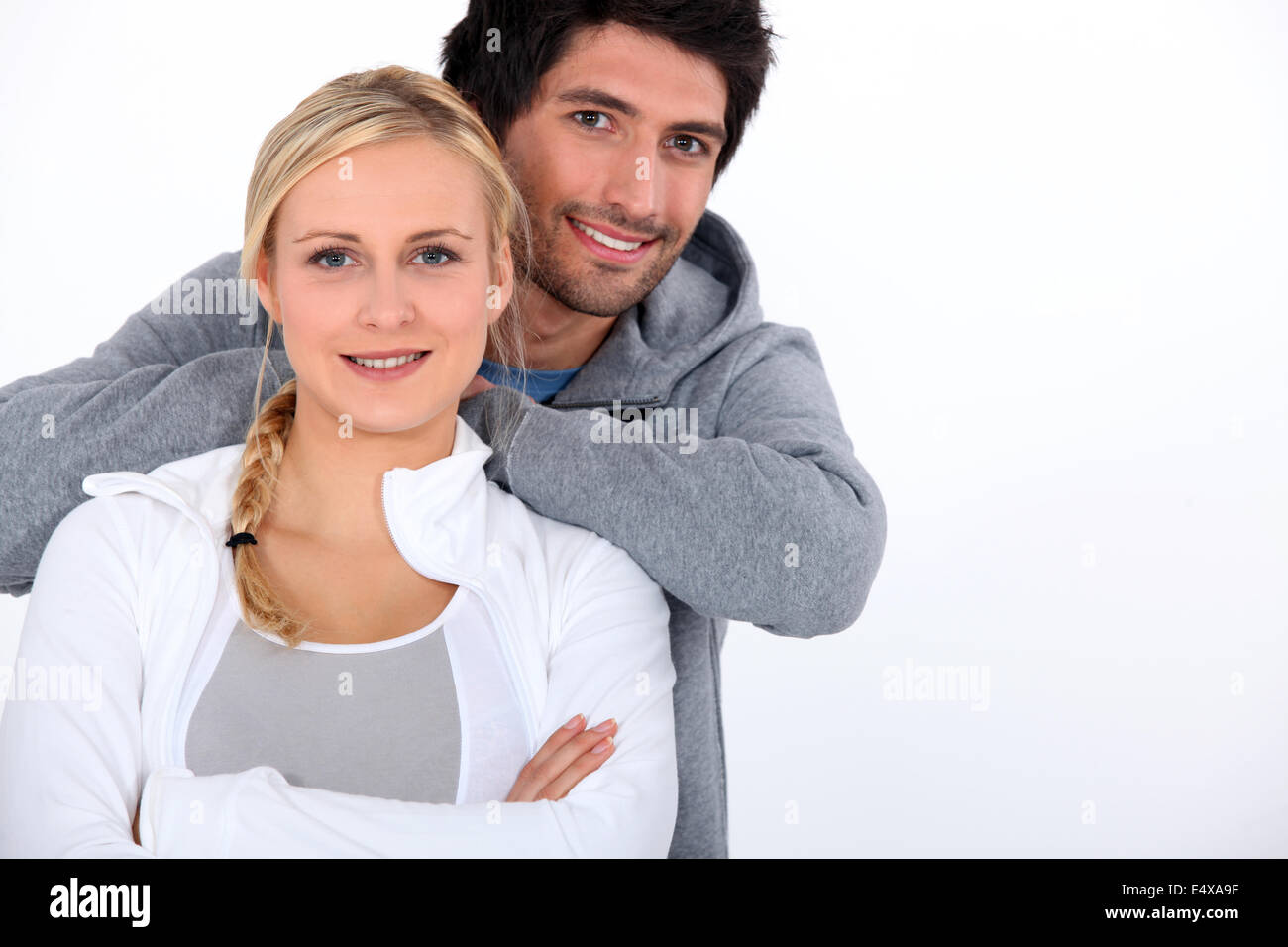 Couple smiling with arms crossed Stock Photo - Alamy