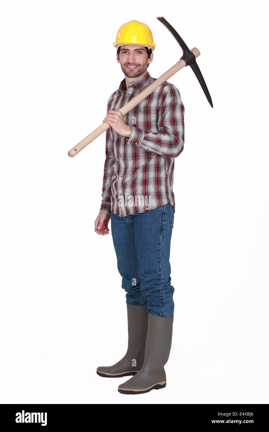 Labourer carrying a pickaxe Stock Photo - Alamy