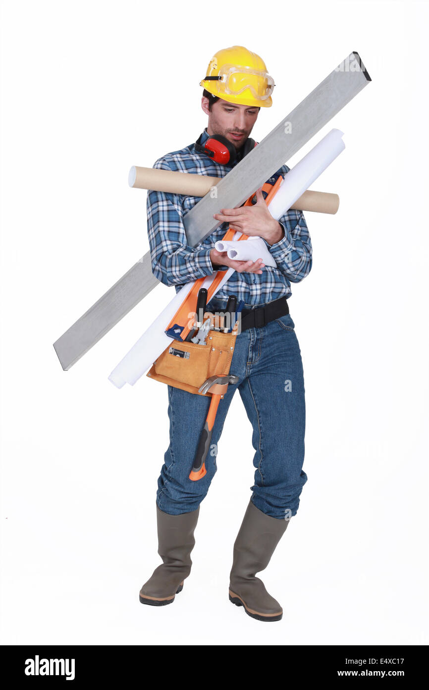 Builder struggling to carry equipment Stock Photo - Alamy
