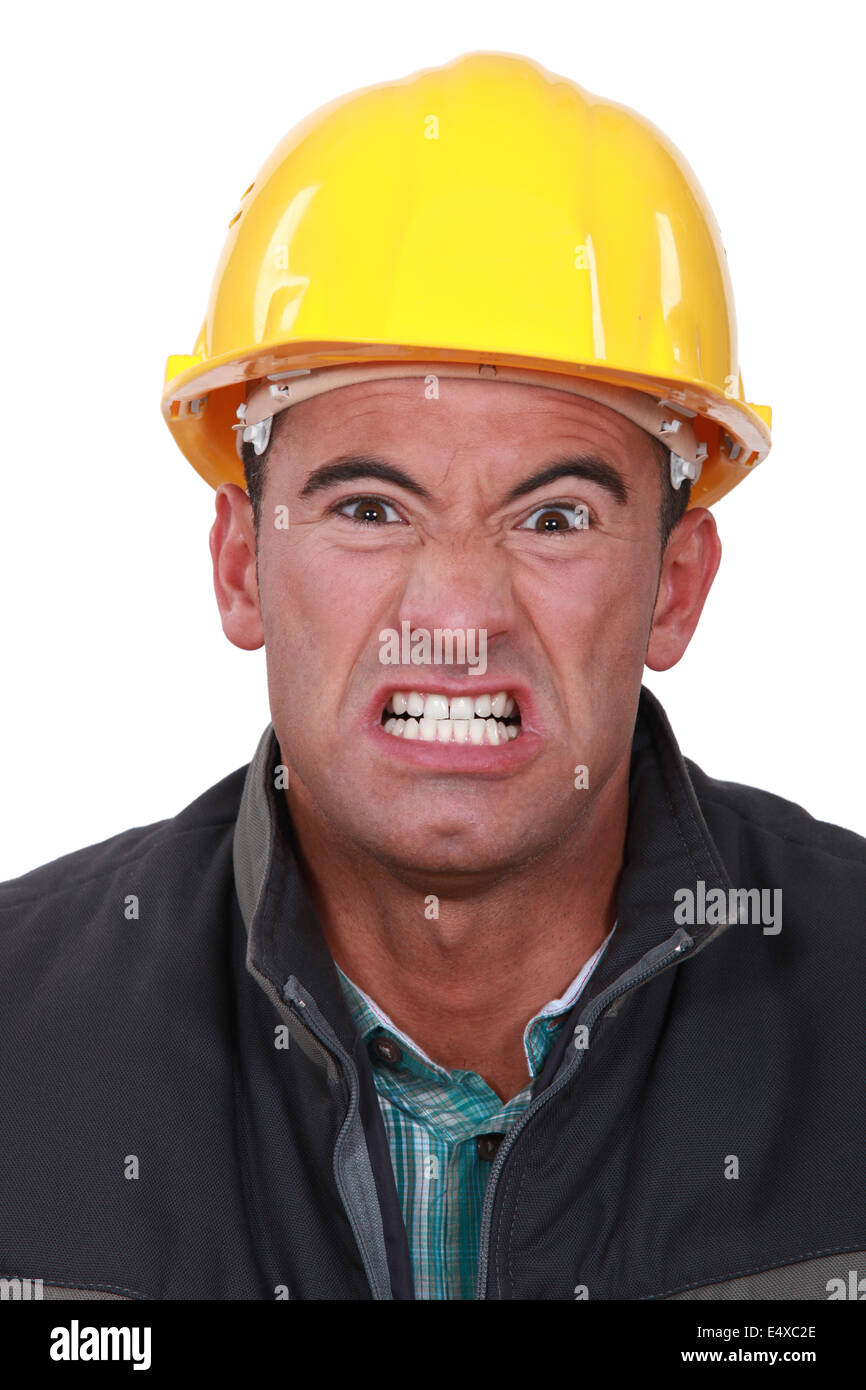 Angry builder grimacing Stock Photo - Alamy